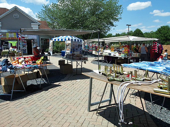 Shoppers browse under blue skies at Pocono Bazaar, where mountains peek through the clouds behind rows of colorful merchandise.