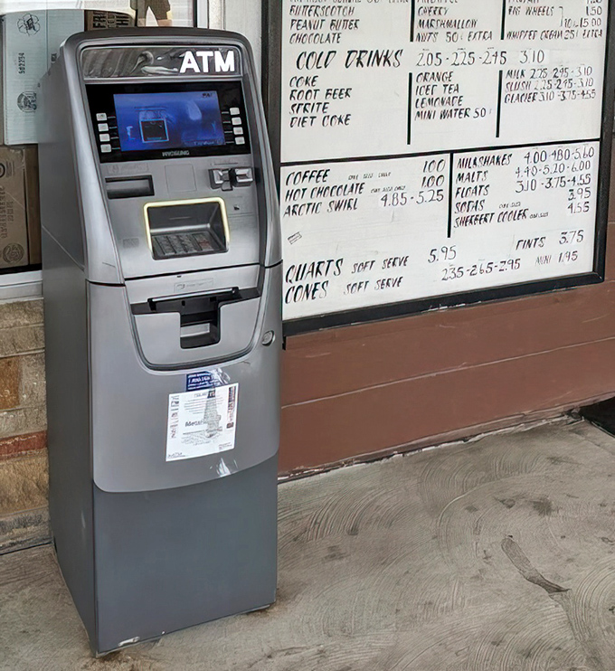 Modern meets classic &ndash; an ATM stands beside a handwritten menu board, bridging convenience with the timeless appeal of tradition.