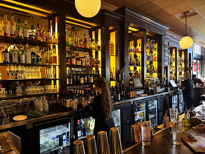 The bar at Guild House isn't just stocked&mdash;it's a liquid library of possibilities, backlit to showcase bottles like precious artifacts of merriment.