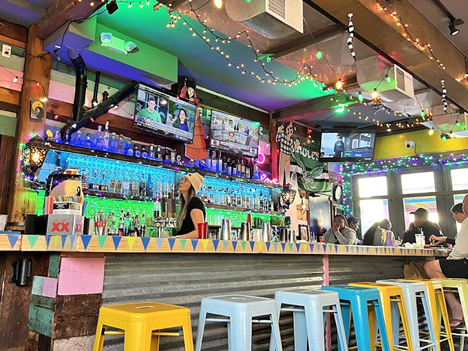 The bar glows like a neon rainbow, where colorful stools wait for their next occupant's taco tales.