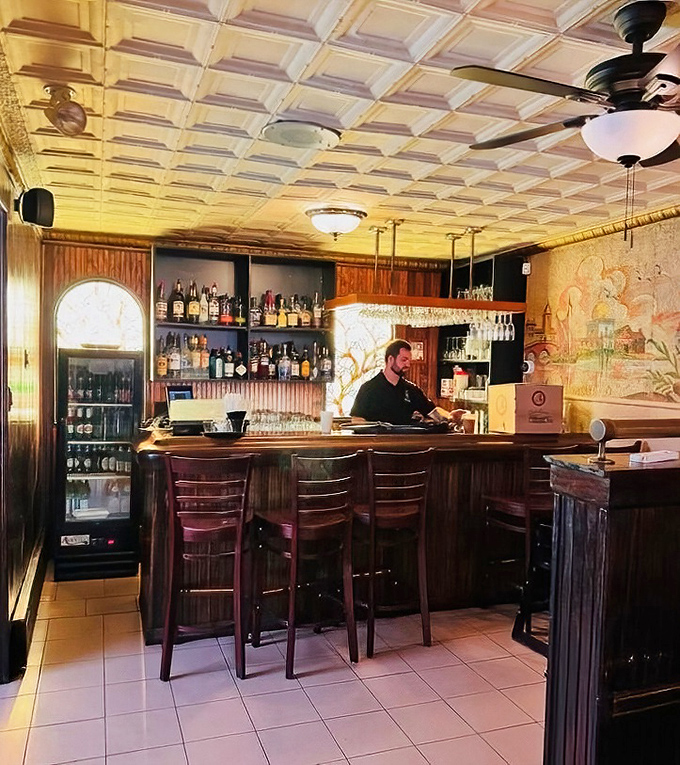 The bar area glows with amber light and possibility. A perfect spot to sip a glass of Chianti while waiting for your table.