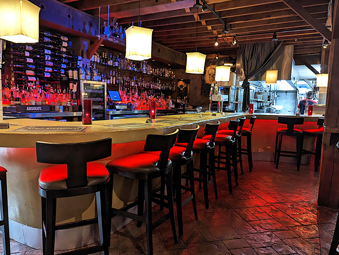 The bar glows with promise, its red-cushioned stools inviting you to perch and ponder life's important questions&mdash;like "Another round?"