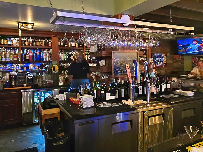 The bar doesn't just serve drinks; it creates liquid memories beneath hanging glasses that catch the light like crystal chandeliers in a maritime palace.