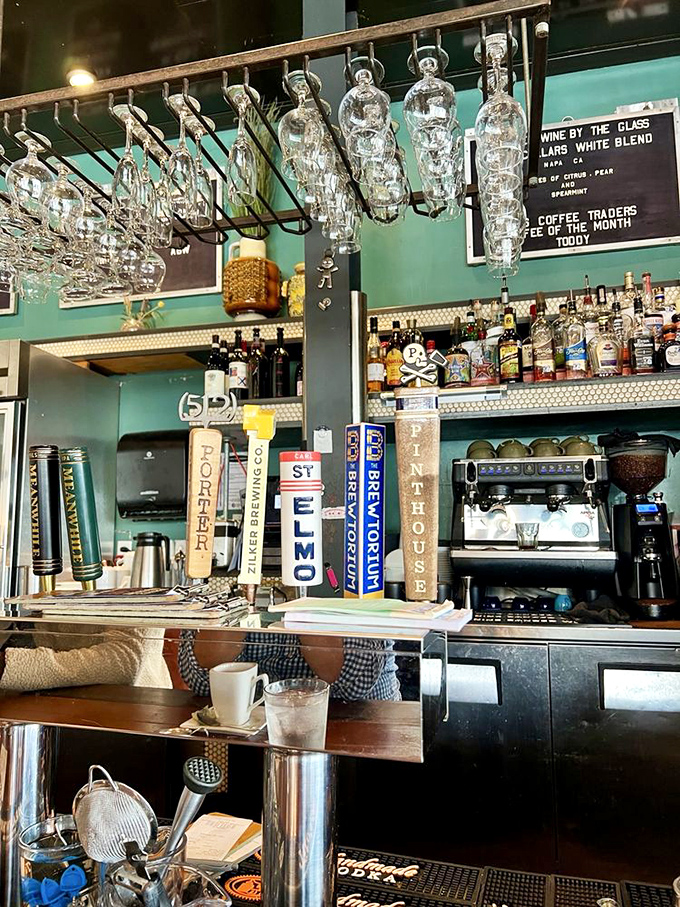The bar area balances form and function, with hanging glassware that catches the light like crystal chandeliers for the cocktail crowd.