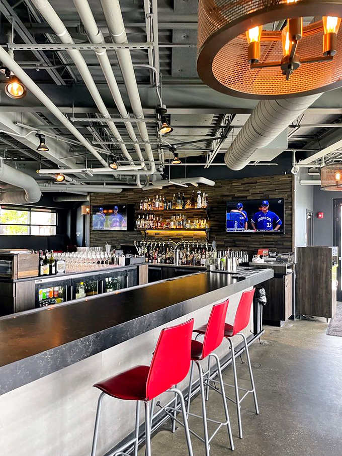 A bar that understands drinking is a social sport. Those red chairs aren't just seating&mdash;they're invitations to stay longer than you planned.