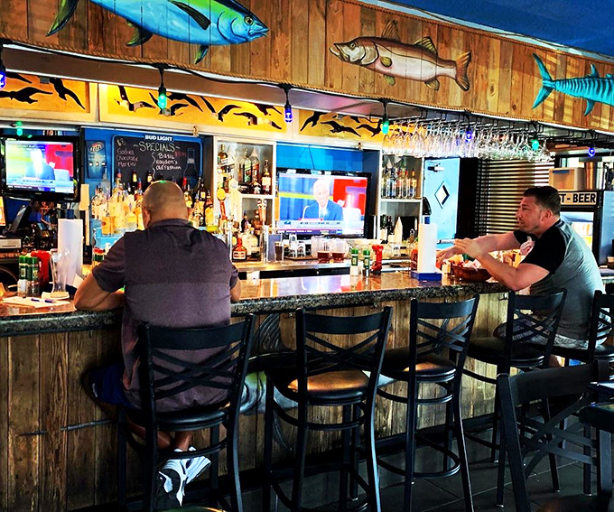 The bar area, where fishing tales get taller with each round. Those wooden fish mounted above aren't just decor &ndash; they're silent witnesses to decades of stories.