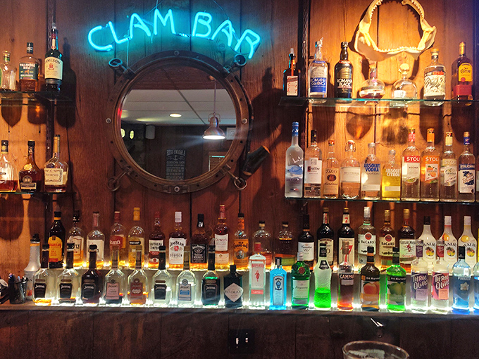 The "Clam Bar" sign glows like a blue beacon above bottles standing at attention, ready to complement your seafood adventure.