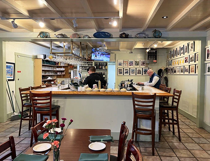 The bar area – where maritime photos and wine bottles create the perfect backdrop for pre-dinner anticipation.