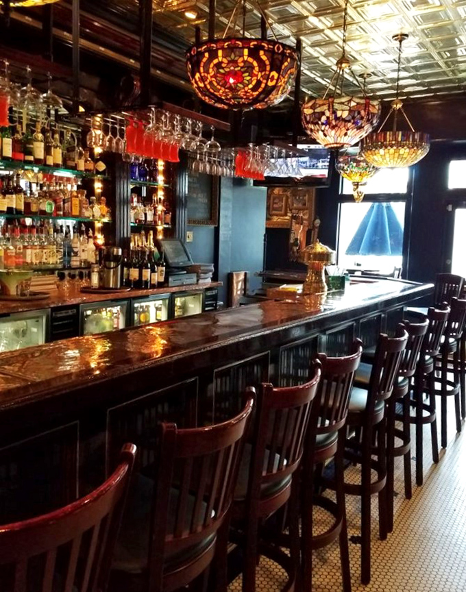 The bar gleams with amber bottles and Tiffany-style lamps, promising cocktails mixed with equal parts skill and generous pours.