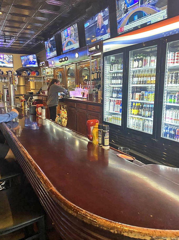 The bar stretches invitingly, promising cold drinks and warm conversation. Those condiment bottles stand ready for whatever culinary adventure you choose.