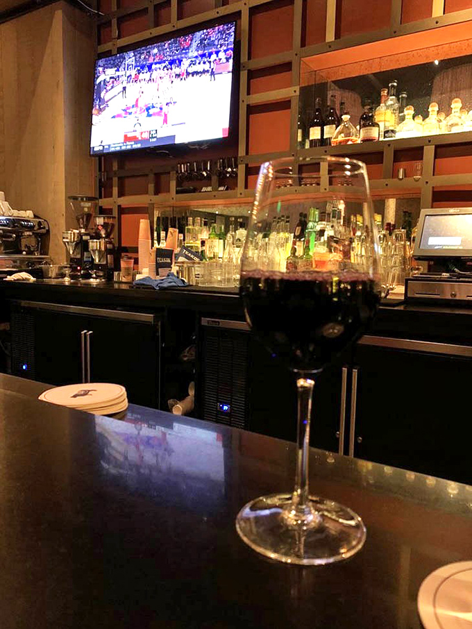 Behind the bar, bottles stand at attention like soldiers ready for cocktail duty, backlit to showcase their amber, gold and crystal-clear contents.