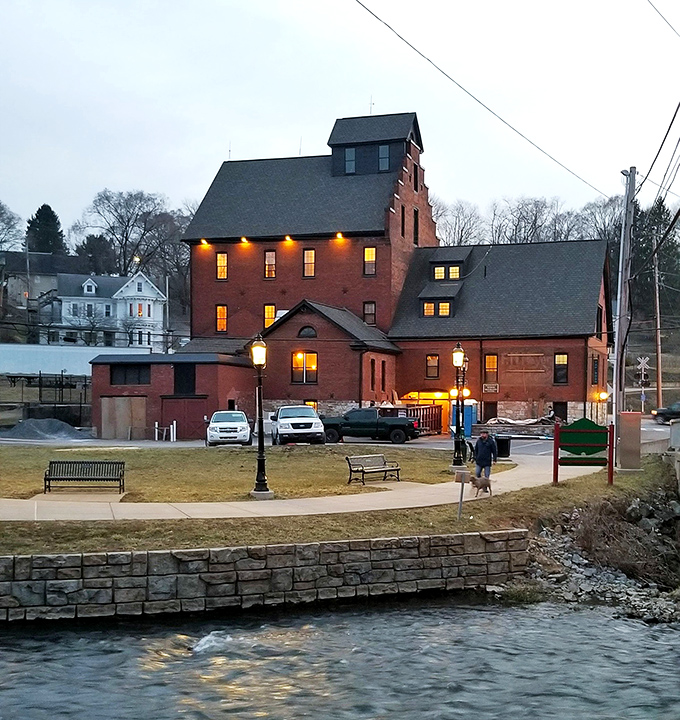 As dusk settles, the Bellefonte waterfront transforms into a magical space where the rushing water provides nature's perfect soundtrack to an evening stroll.