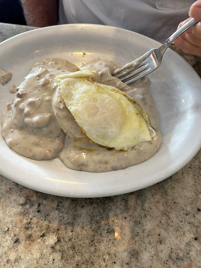 Biscuits and gravy with an egg on top – the breakfast equivalent of hitting the jackpot on a slot machine that only pays in comfort.