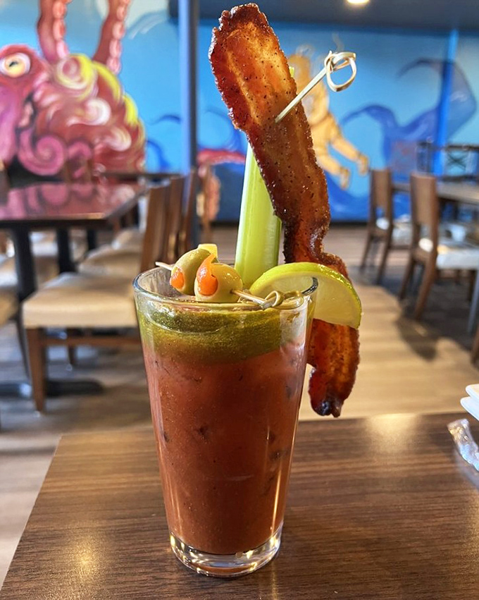 A Bloody Mary that doubles as an appetizer, complete with a bacon strip that serves as both garnish and snack—multitasking at its finest.