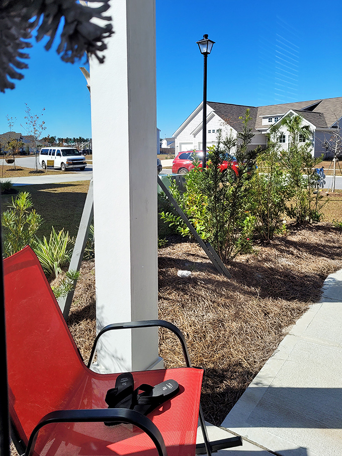 Front porch sitting reaches art form status in Summerville neighborhoods, where red chairs invite conversations that last longer than intended.
