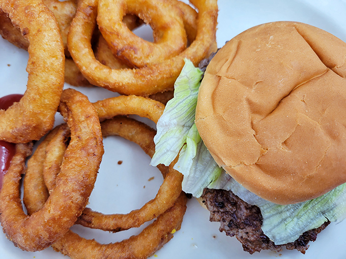 A burger that doesn't need fancy toppings to impress, paired with onion rings that crunch loud enough to turn heads. Diner perfection.