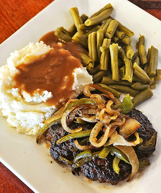 A steak that's found its perfect companions: crisp green beans and cloud-like mashed potatoes. The saut&eacute;ed onions and peppers are wearing their caramelized best.