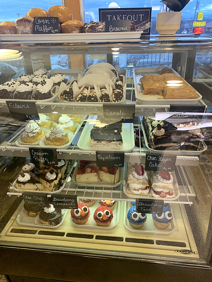 A dessert case that makes willpower go on immediate vacation. Those owl-faced cupcakes are judging your restraint.