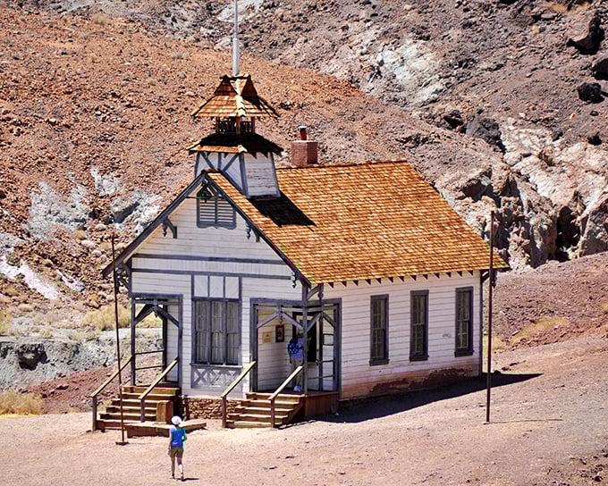 The schoolhouse stands pristine against the rugged landscape, its bell tower ready to summon phantom students. Education didn't wait for civilization out West.