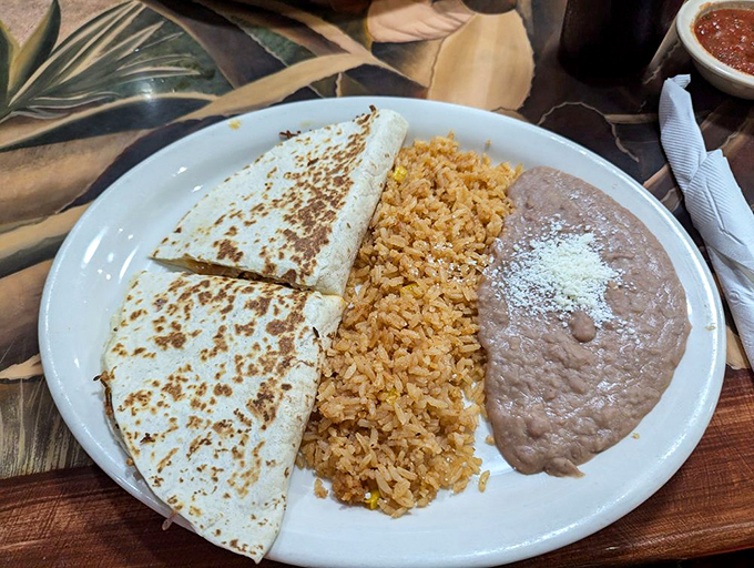 The quesadilla trinity: perfectly grilled tortilla, melted cheese, and that rice and beans duo that completes the holy experience.
