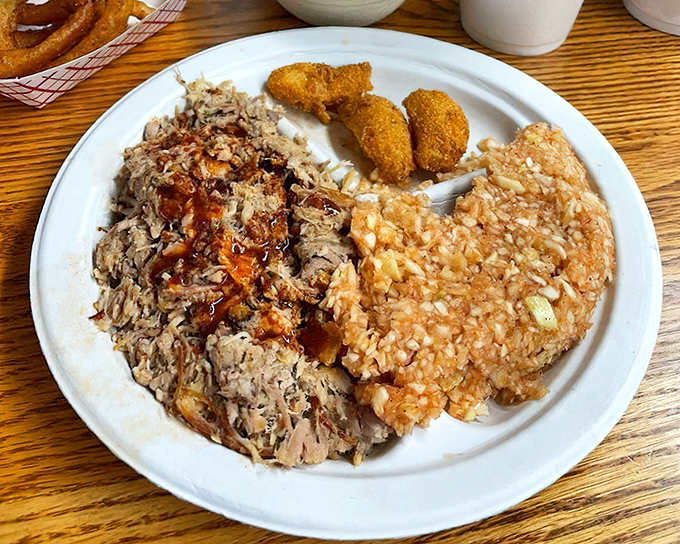 The holy trinity of North Carolina barbecue: chopped pork, red slaw, and hush puppies. A plate that tells the story of generations.