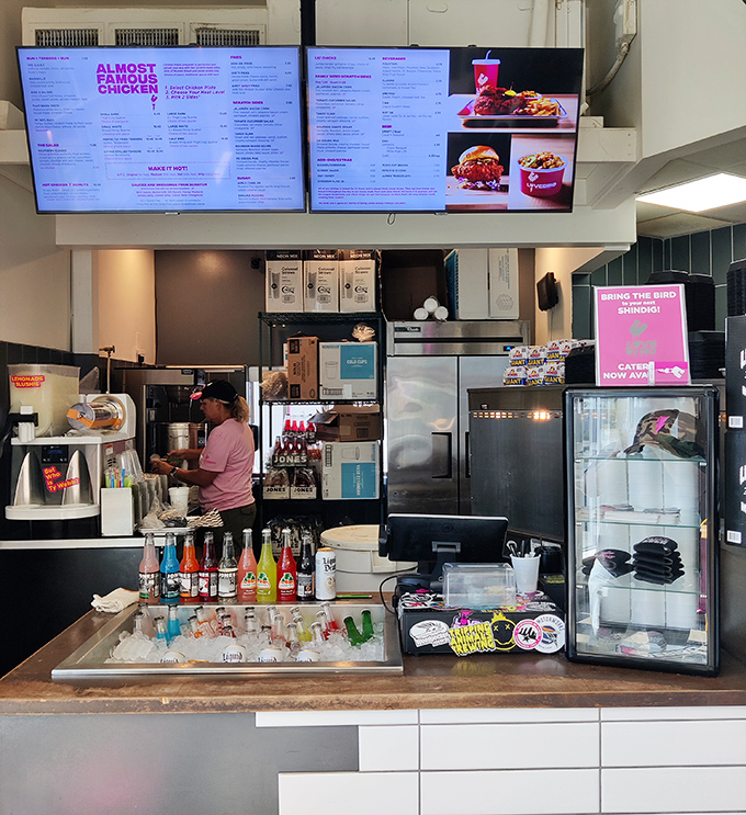 
The digital menu boards loom above a counter stocked with colorful sodas &ndash; a modern touch in a place that honors traditional fried chicken techniques.