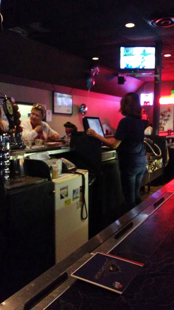 The bar area glows with that perfect reddish hue where everyday troubles dissolve faster than ice in a warm Manhattan.