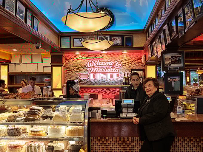 The welcome sign glows like a beacon, with display cases of desserts that make willpower pack its bags and leave town.