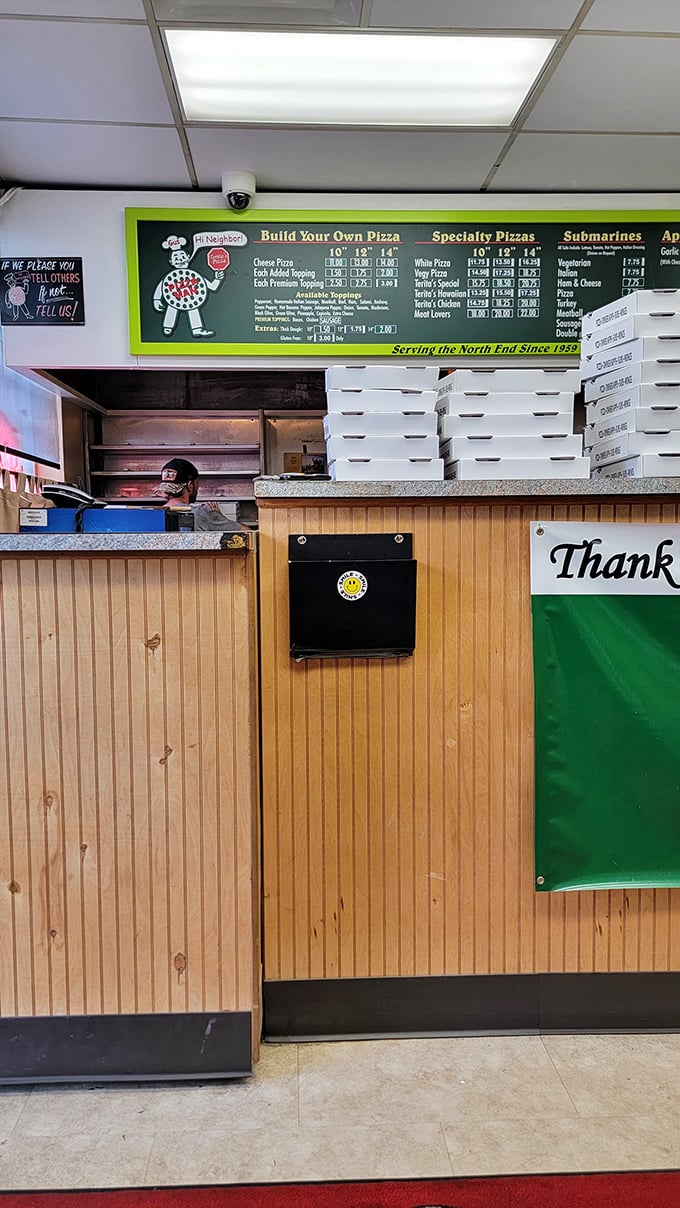 Behind this counter, pizza wizards work their magic while stacks of boxes await hungry neighborhoods.