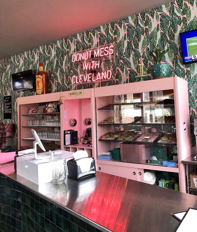 The "DONUT MESS WITH CLEVELAND" sign glows like a pink beacon of hope in a world that desperately needs more frosting.