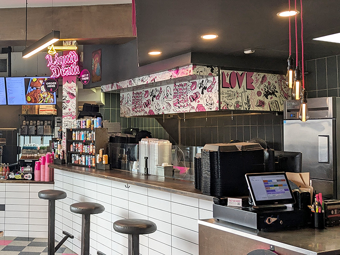 Behind this counter, culinary magic happens. The neon "Liquid Death" sign seems appropriate for a place that kills it with flavor.