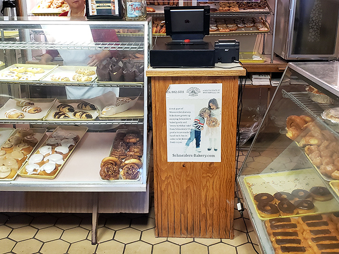Behind this wooden counter, dreams come true one donut at a time. The hexagon floor tiles have witnessed generations of sugar-fueled happiness.