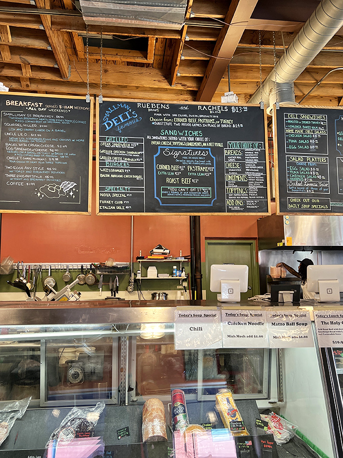 Behind these chalkboards and counters lies a world of deli magic where sandwiches are built with architectural precision.