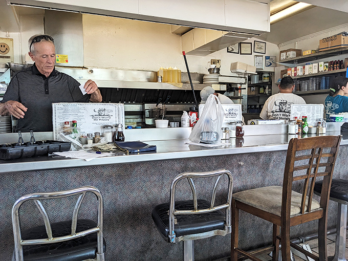 The open kitchen design lets diners witness the breakfast magic happening behind the classic diner counter.
