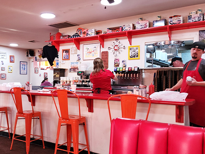 The counter seating offers front-row tickets to the kitchen symphony, where red and white decor creates that classic American diner feel.