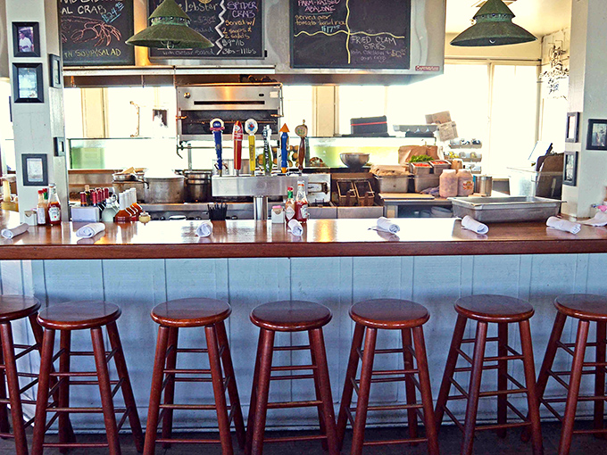 Counter seating where strangers become friends over shared plates and spectacular harbor views through every window.
