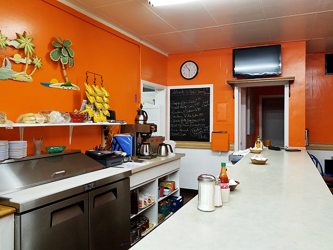 Behind the scenes where breakfast magic happens. Orange walls and a chalkboard menu &ndash; the command center of comfort food.
