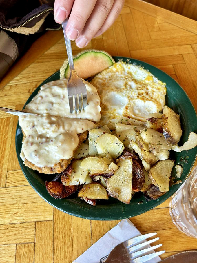 Country fried steak smothered in gravy with eggs and home fries&mdash;a breakfast so hearty it could fuel a day of chopping down pine trees.