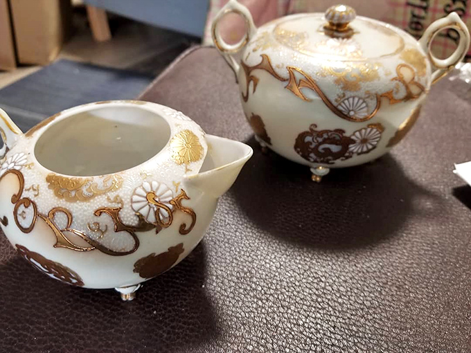 Delicate gold-trimmed porcelain tea service that whispers of afternoon gatherings where gossip flowed as freely as the Earl Grey.