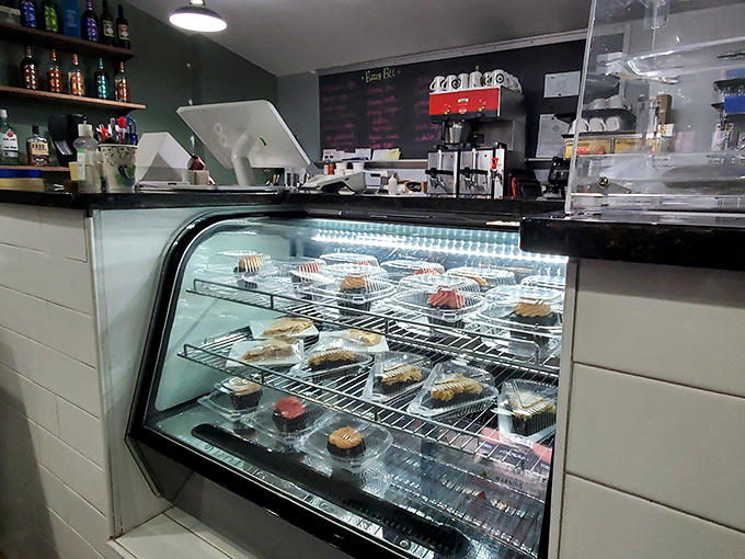 The dessert case stands as a glass-enclosed temple of temptation, where willpower goes to die a deliciously sweet death.