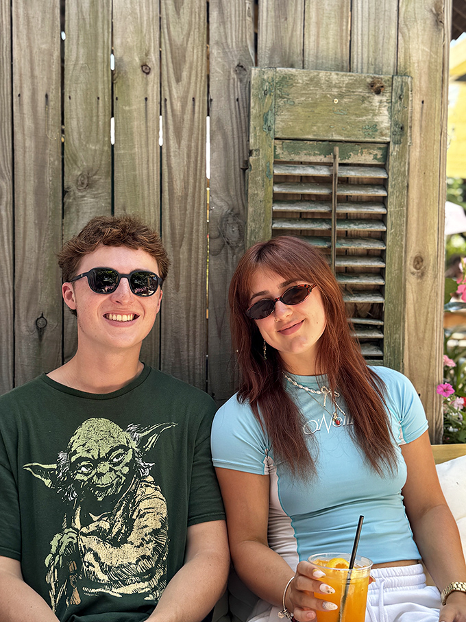 The outdoor seating area feels like discovering a secret garden, where conversations flow as easily as the cocktails under bright yellow umbrellas.