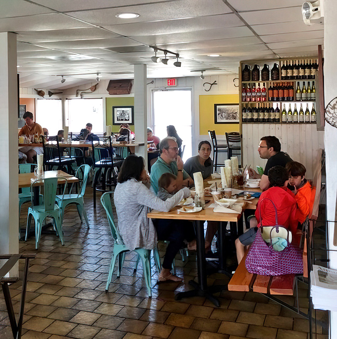 Families gather around wooden tables, sharing seafood feasts and creating memories in a space that feels both special and comfortably casual.