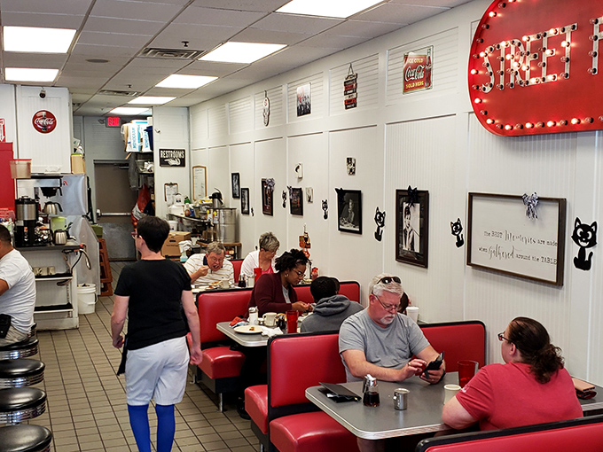 Red booths filled with diners experiencing breakfast bliss. Notice nobody's on their phone&mdash;they're too busy having religious experiences with their pancakes. 