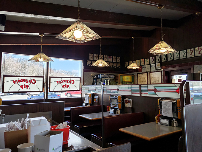Pendant lights cast a warm glow over wood-paneled walls, creating the perfect backdrop for conversations that stretch long after the plates are empty.