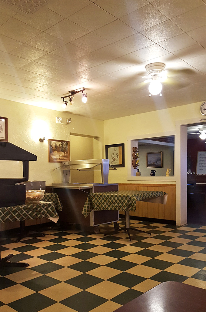 The checkered floor and warm lighting create that timeless diner atmosphere where conversations flow as freely as the coffee.