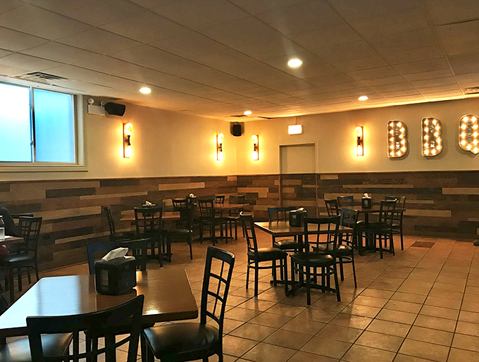 The second dining area feels like a modern saloon &ndash; warm lighting, wood-paneled walls, and those illuminated BBQ letters promising good things to come.