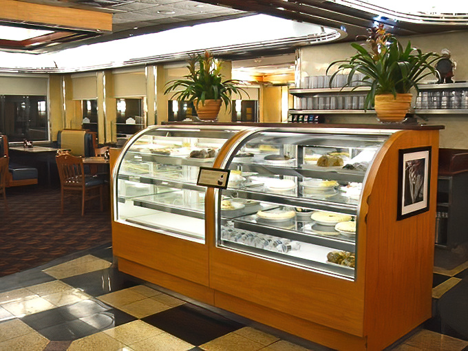 The dessert case stands as a shrine to sweet temptation, where pies and cakes patiently wait their turn to ruin your diet plans.