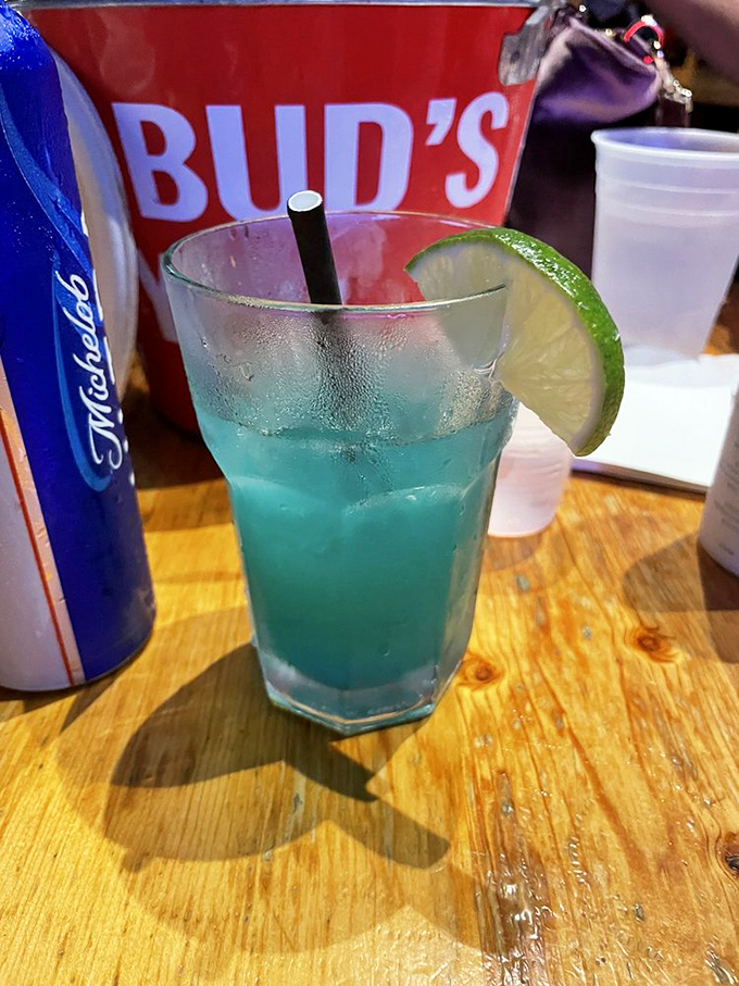 Electric blue cocktail with a lime garnish&mdash;like drinking a summer sky. The kind of drink that makes Monday feel like Friday.