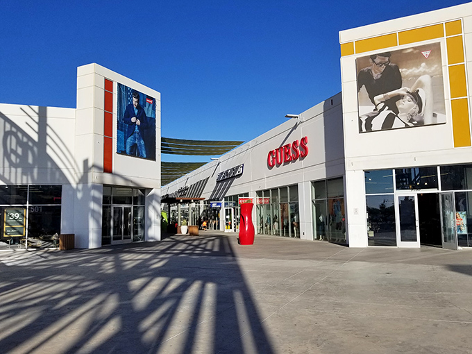 Architectural shadows play across the entrance like sundials marking the hours you'll spend convincing yourself that yes, you did need another pair of jeans.