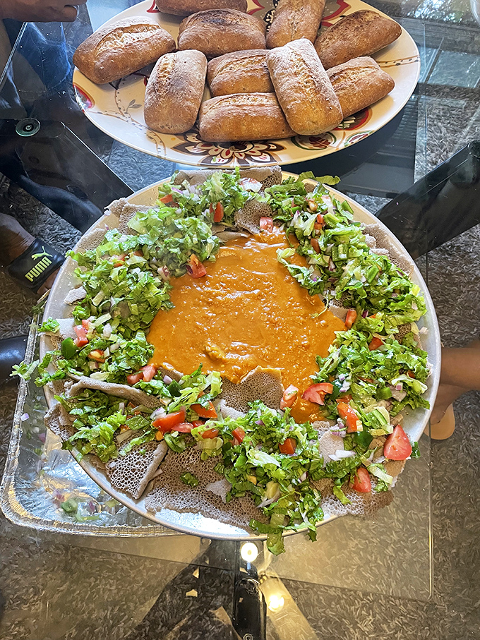The Eritrean feast arrives like an edible color wheel, where yellows, greens, and reds represent different lentils, vegetables, and spices.